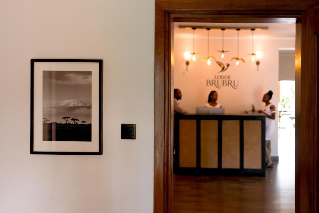 Uma área de recepção com uma placa indicando 'LODE BRUBRU' e um quadro na parede.