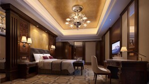Quarto de hotel com uma cama grande, uma escrivaninha, uma cadeira, uma televisão e um lustre.