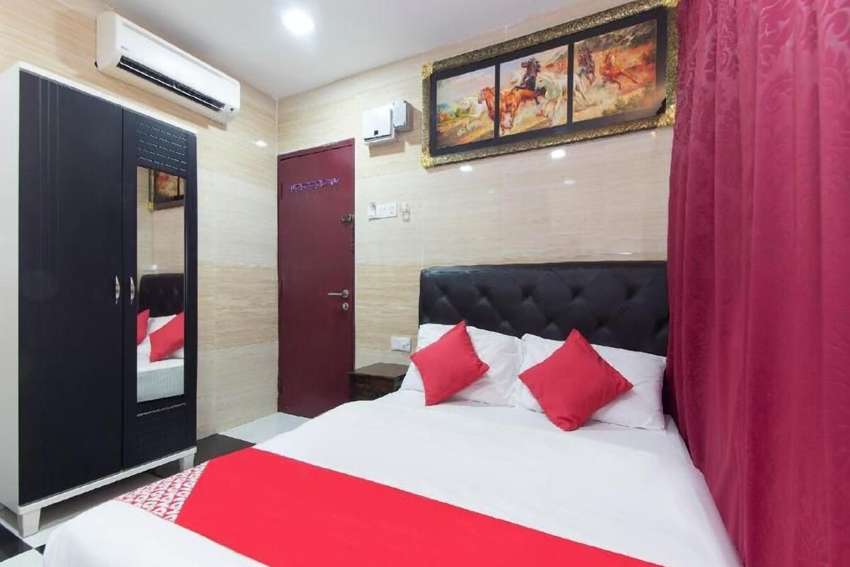 Quarto de hotel com cama, guarda-roupa, porta e um quadro na parede.