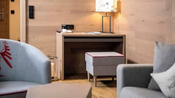 Quarto moderno com escrivaninha, luminária e dois poltronas cinzentas.