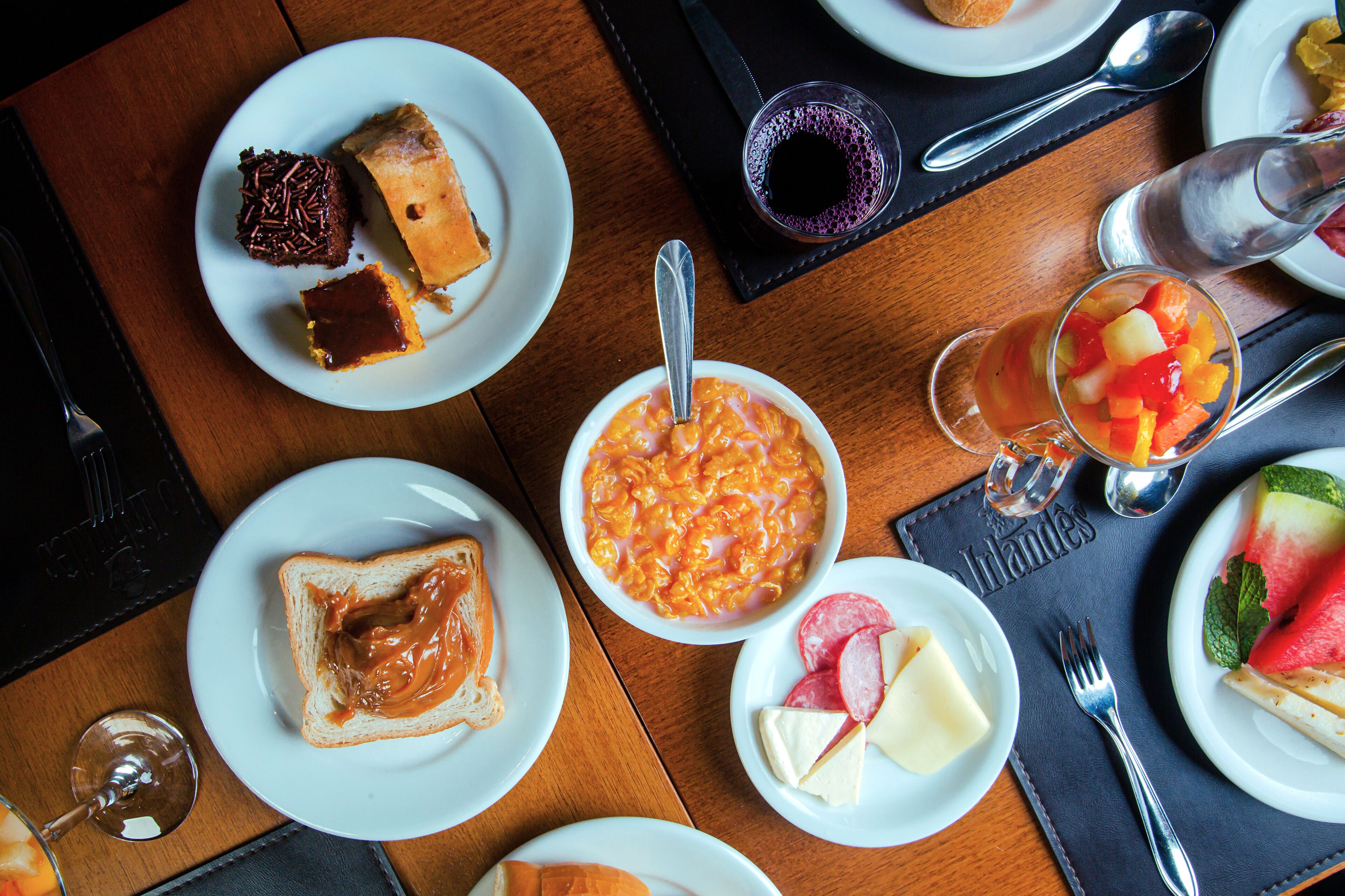 Uma mesa de jantar com diversos pratos, incluindo pão, uma tigela de sopa e pratos com diferentes tipos de comida.