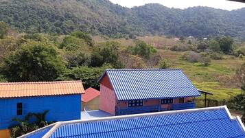 Uma aldeia rural com casas coloridas e uma paisagem verdejante.