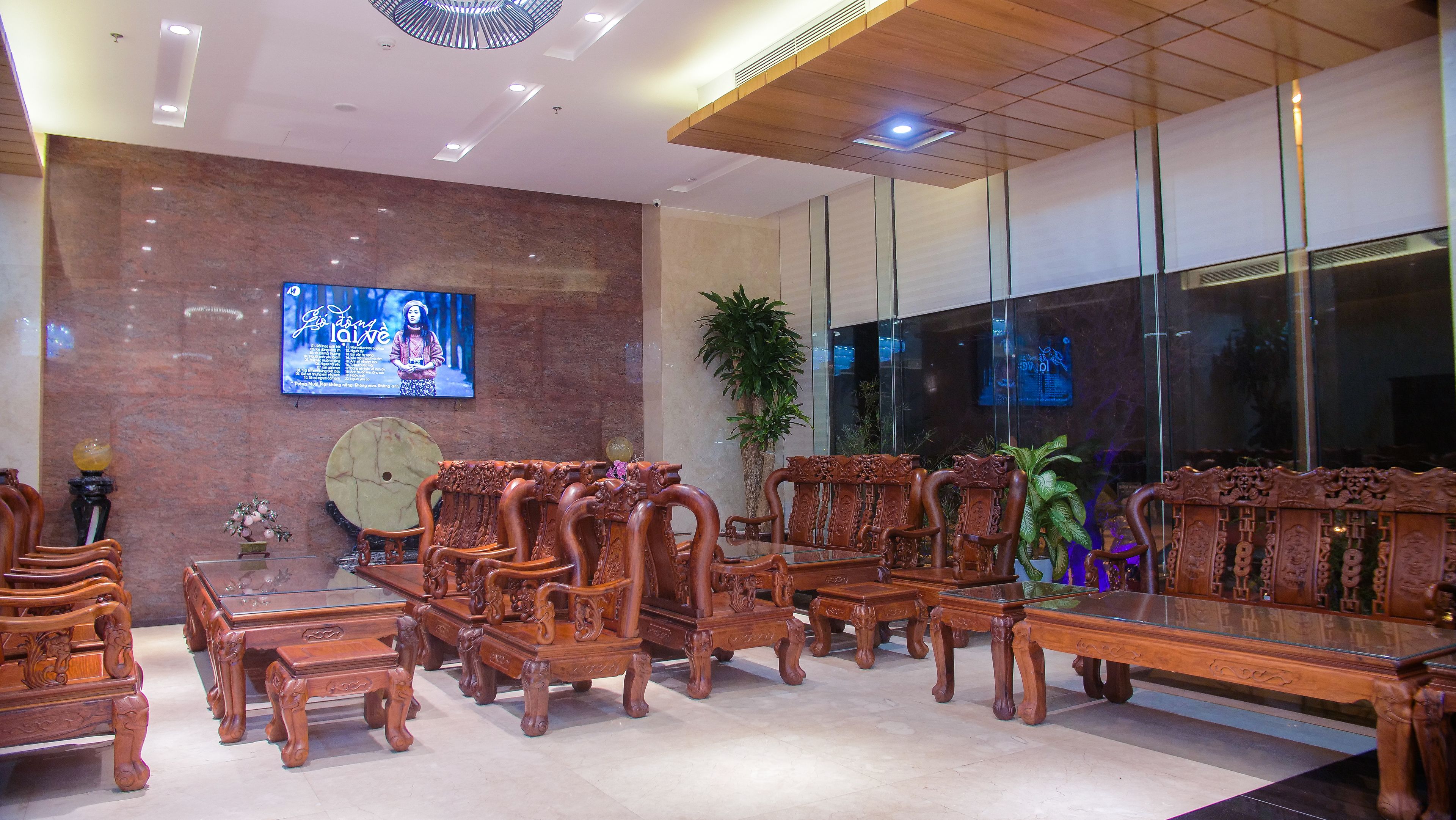 Um hall de entrada com mobiliário de madeira tradicional, uma grande tela de TV e um design de teto moderno.