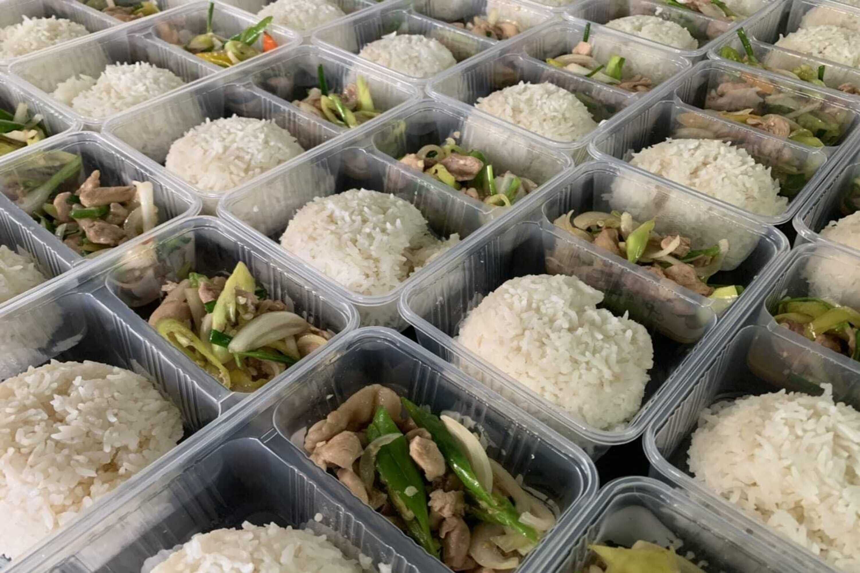Vários recipientes de plástico cheios de arroz, diferentes vegetais e carnes.