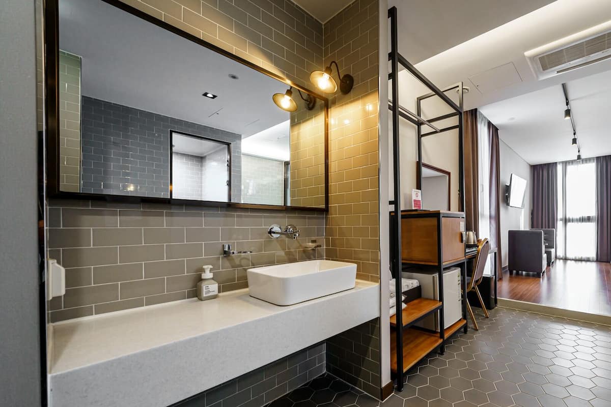 Casa de banho moderna com duas pias, um espelho grande e zona de duche.