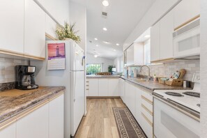 Apartamento em Condomínio Fechado, 2 quartos | Cozinha privada | Um frigorífico/congelador grande, um micro-ondas, um forno 