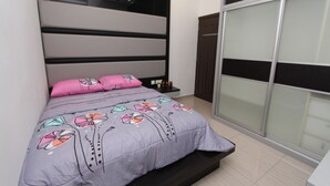 Quarto com cama, mesa de cabeceira, guarda-roupa e porta de vidro deslizante.