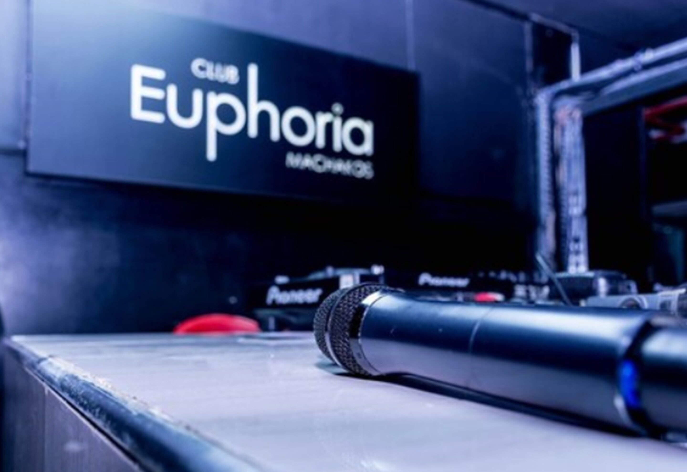 Um microfone em um palco com um letreiro que diz 'Club Euphoria'.