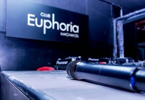 Um microfone em um palco com um letreiro que diz 'Club Euphoria'.
