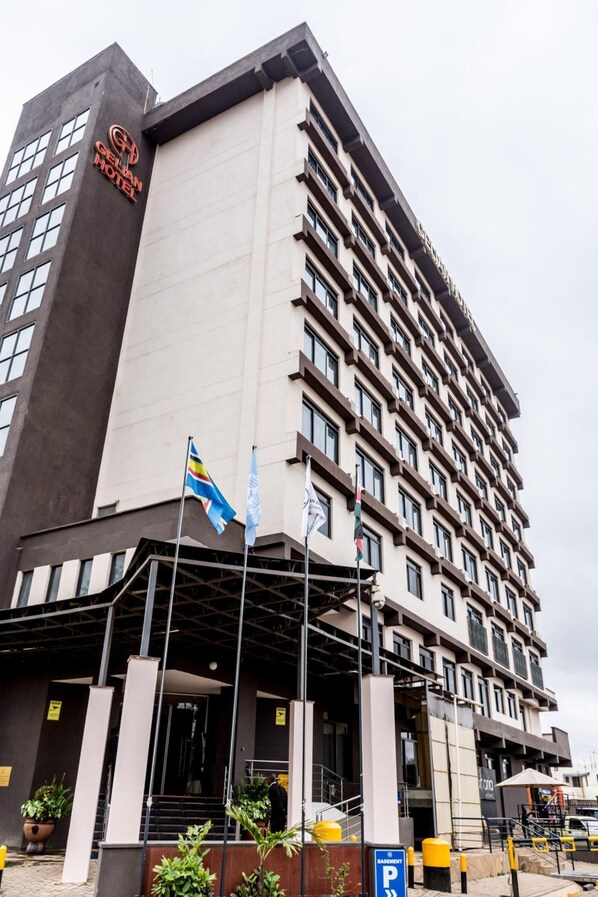 Hotel com design moderno, destacando uma entrada imponente e diversas bandeiras.