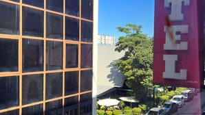 Um hotel com fachada de vidro ampla e placa vermelha destacada.