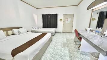 Quarto de hotel com duas camas, banheiro e bancada com amenities de higiene.