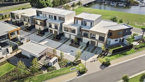 Uma área residencial moderna com casas contemporâneas, um porto de iates e uma ponte.