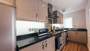 Uma cozinha moderna com micro-ondas, fogão e pia.