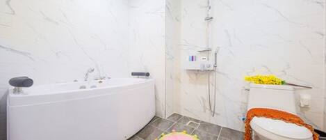 Um banheiro com banheira, vaso sanitário e chuveiro.