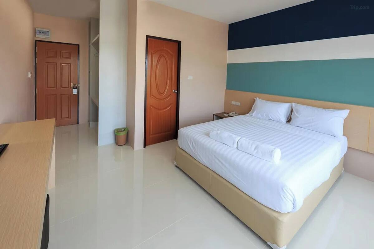Quarto de hotel com uma cama, uma mesa e uma porta.