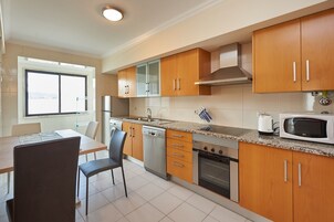 Um frigorífico, um micro-ondas, um forno, uma placa de cozinha 