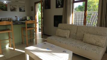 Apartamento conforto, 1 quarto | Área de estar | TV de tela plana 32 polegadas com canais via satélite, TV