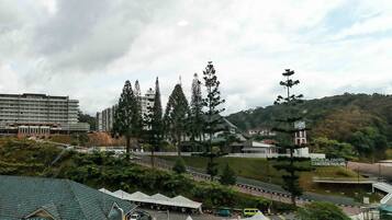 Vista de um hotel com vários edifícios, área de estacionamento e placa indicando 'Majlis Daerah Cameron Highlands'.