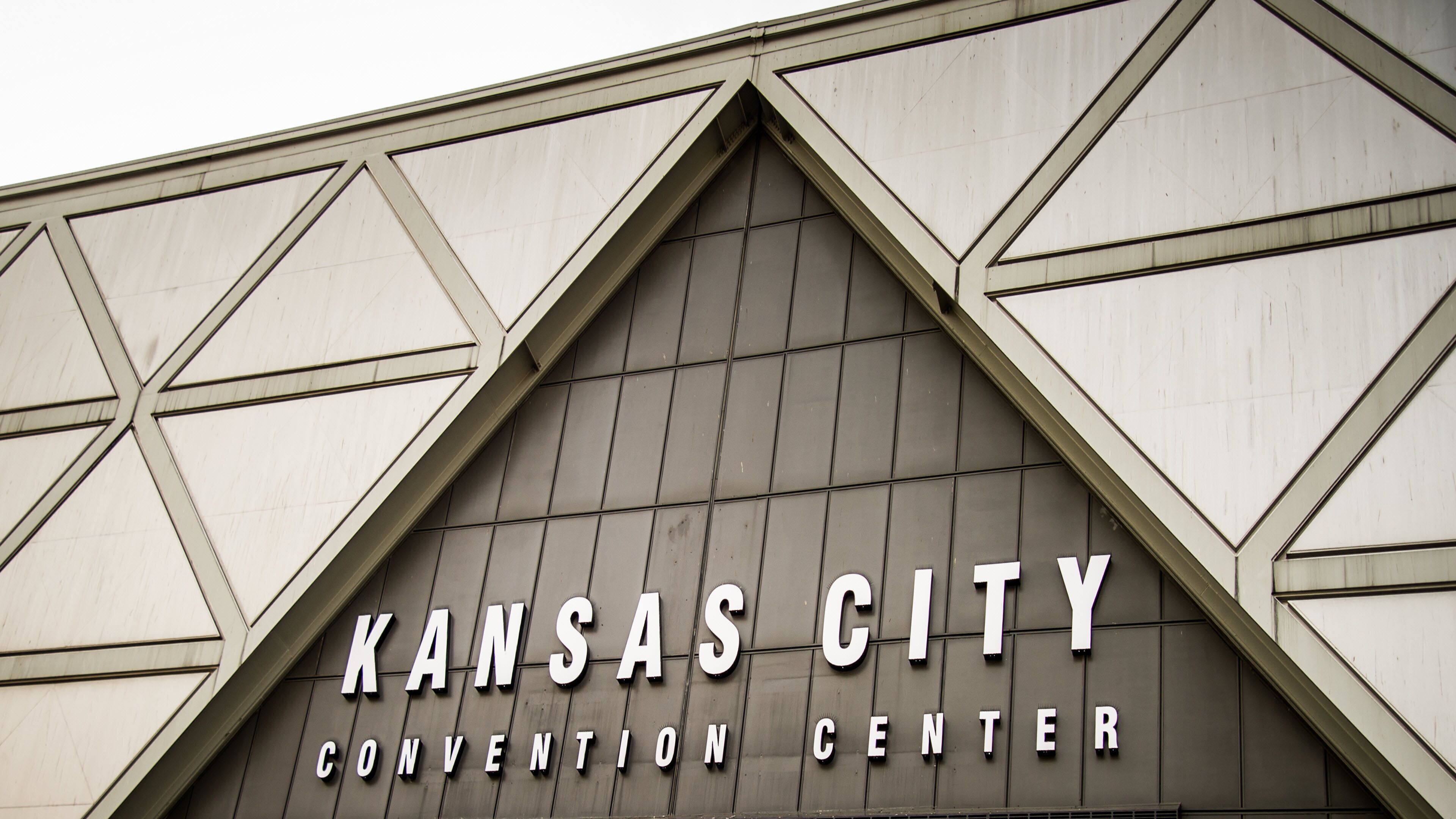 Exterior do Centro de Convenções de Kansas City com uma placa de destaque.