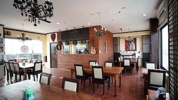 Um restaurante com paredes de tijolo, mesas e cadeiras de madeira.