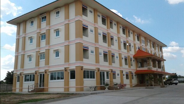 Um hotel de vários andares com fachada simétrica, varandas e entrada central.
