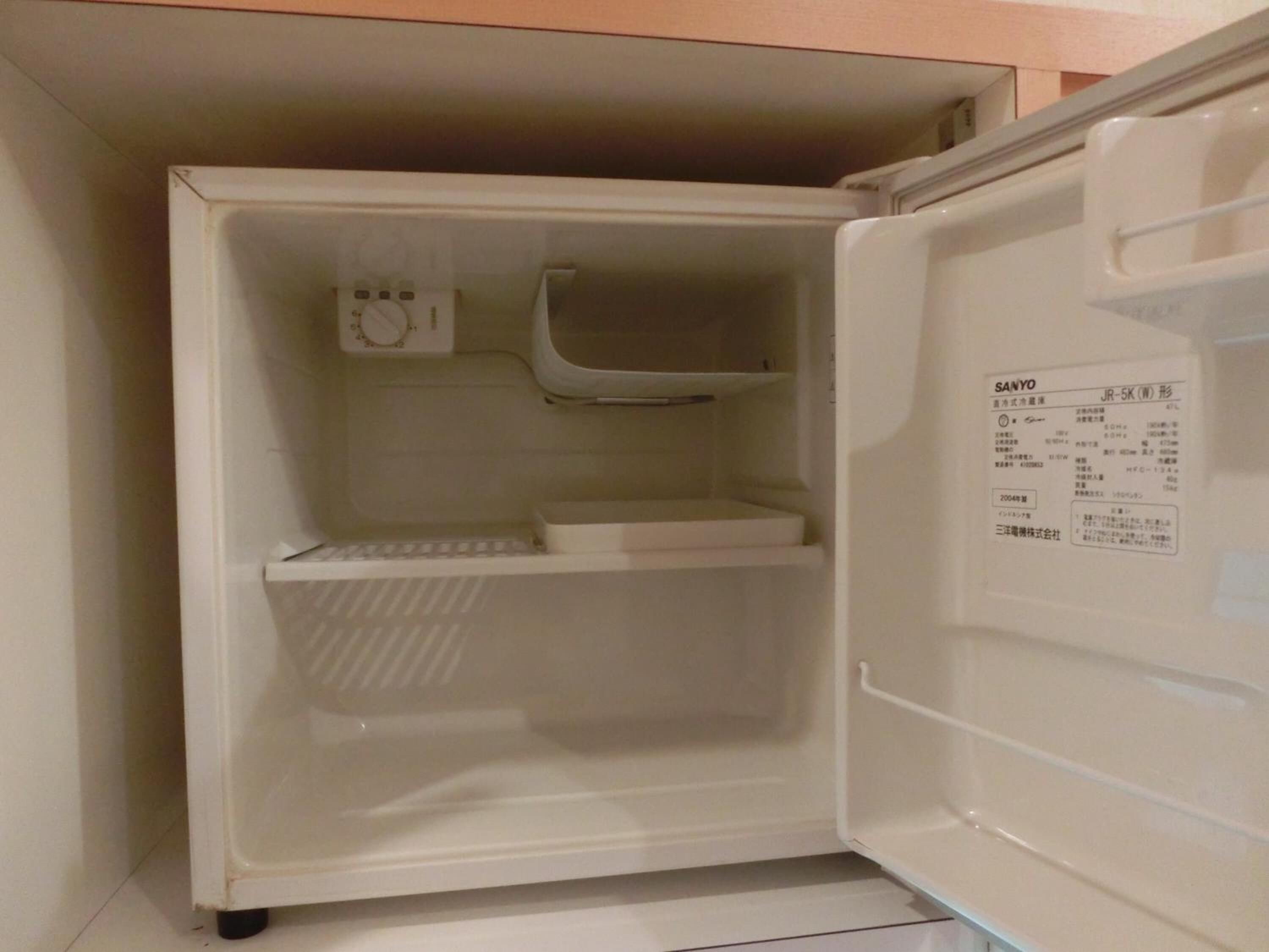 Geladeira aberta com painel de controle e etiqueta na porta.