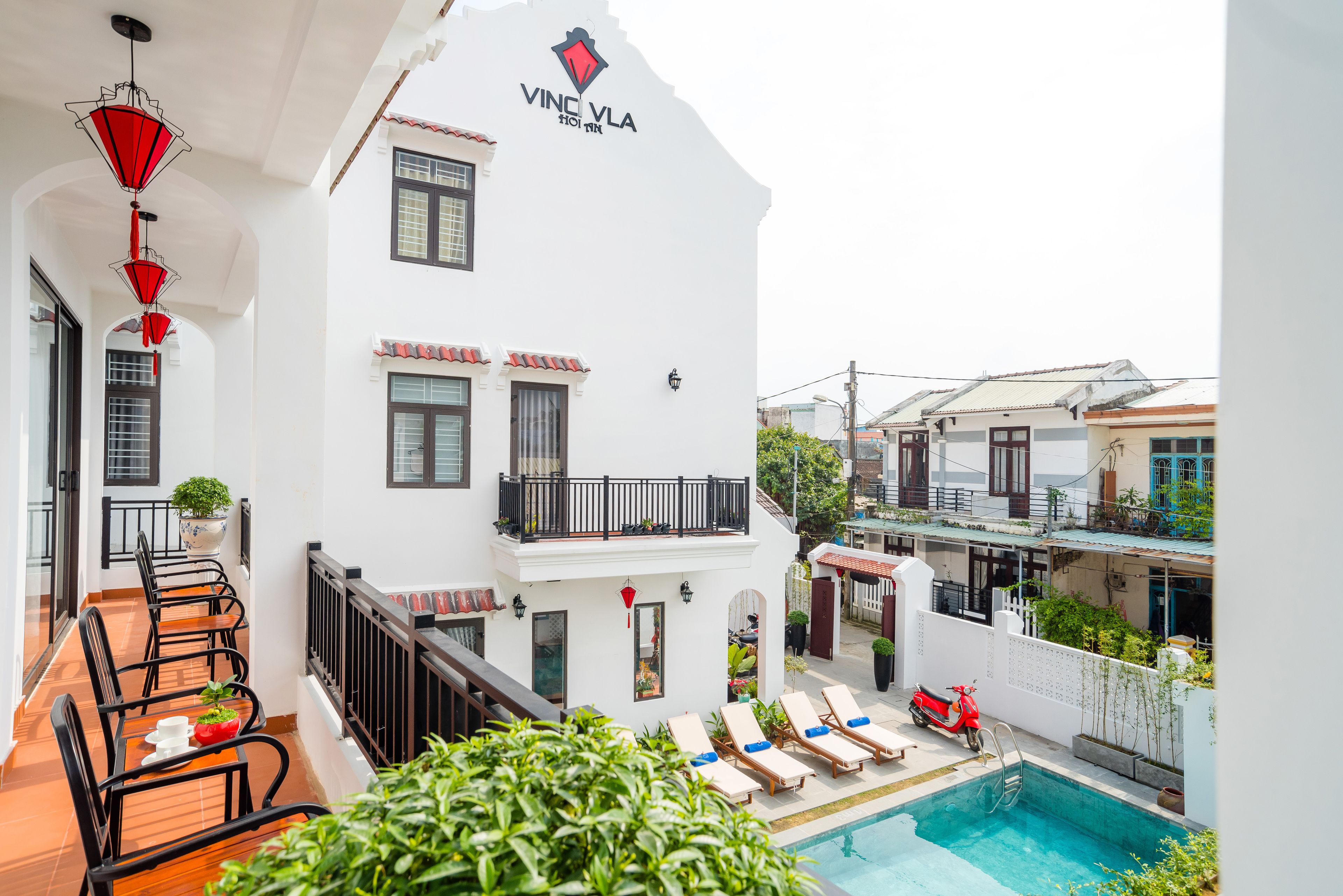 Um hotel com piscina, área de estar ao ar livre e varanda.