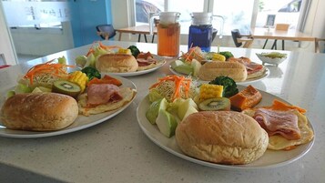 Uma mesa com pratos de comida, incluindo pães, legumes e carnes.