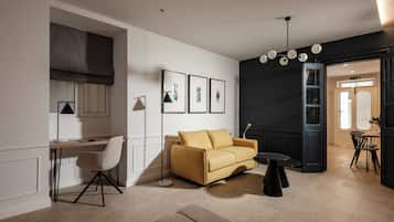 Uma sala de estar moderna com um sofá, uma escrivaninha e um espaço para refeições.