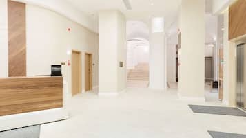 Um hall de hotel moderno com uma mesa de recepção, uma escadaria e design minimalista.