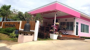 Um edifício moderno com telhado rosa e cerca de madeira.