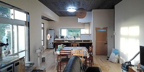 Um espaço compacto com área de refeições, cozinha compacta e uma grande janela que proporciona luz natural.