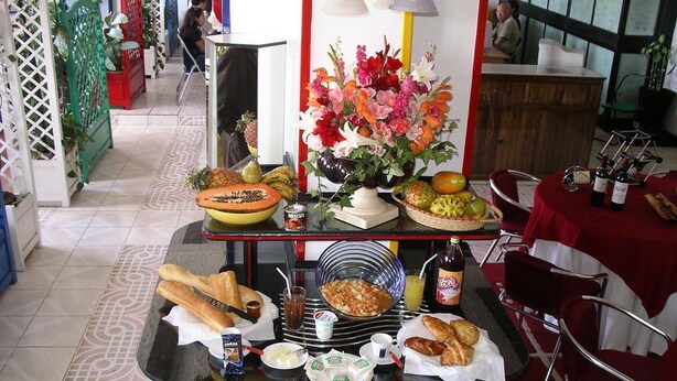 Disposição de buffet com diversos alimentos e um arranjo floral.
