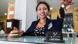 Bancada de recepção de hotel com um sino, uma etiqueta de identificação e uma placa para Hotel de l'Aven.