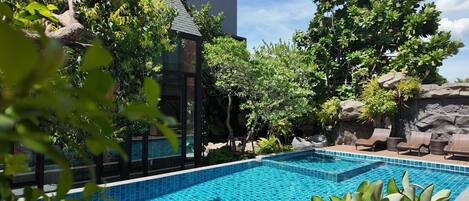 Piscina exterior, uma piscina com cascata, guarda-sóis