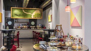 Um café moderno com área de bar, mesas e diversas opções de comida e bebida.