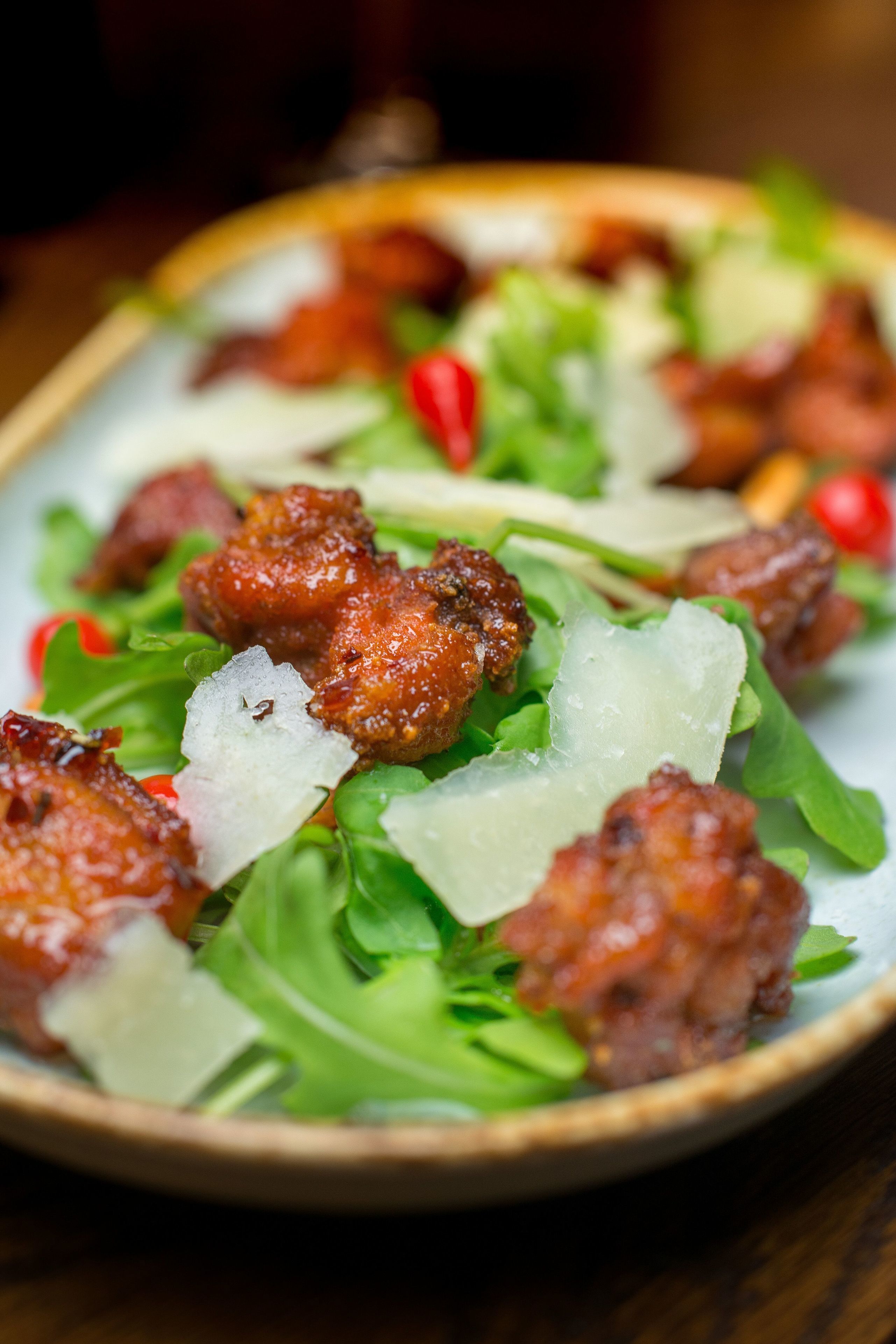 Close-up de um prato com carne, vegetais e queijo.