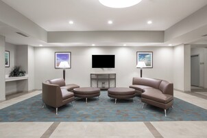 Uma sala de estar moderna com televisão de tela plana, dois sofás e uma mesa de centro.