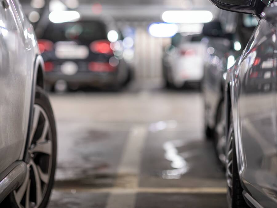 Garagem de estacionamento com carros estacionados em fileiras.