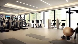 Academia moderna com equipamentos de cardio, estações de musculação e uma grande bola de exercícios.