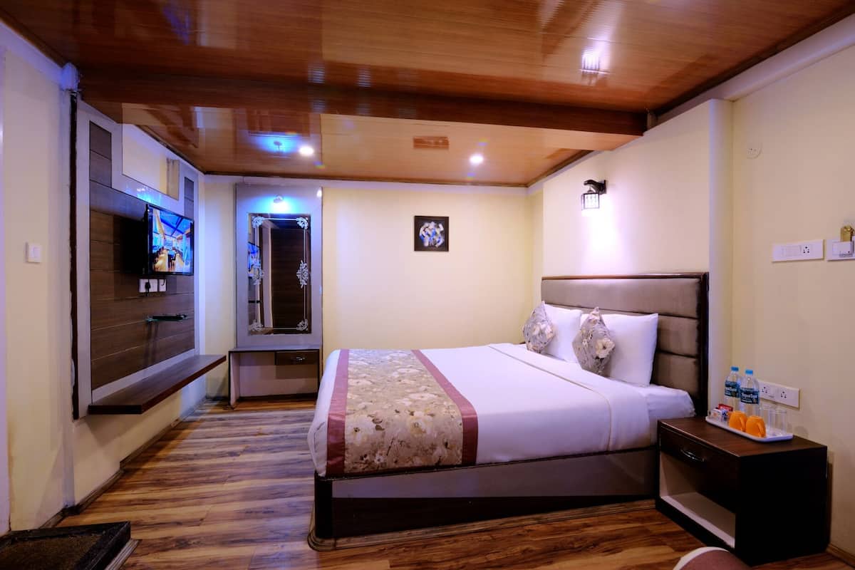 Quarto com cama, mesa de cabeceira e espelho.