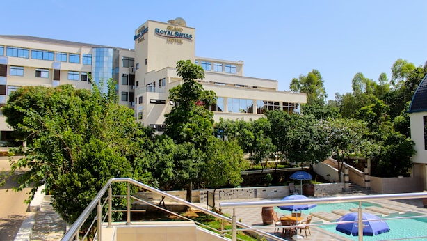 Um hotel com área de piscina, espaço para sentar ao ar livre e escadaria que leva à entrada.