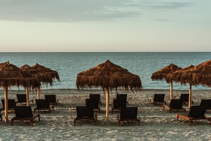 Na praia, espreguiçadeiras, guarda-sóis de praia 