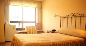 Quarto Individual | Minibar, cofre com capacidade para portátil, secretária