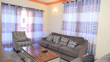 Apartamento empresarial | Área de estar | TV de tela plana