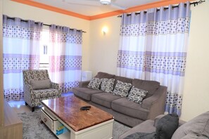 Apartamento empresarial | Área de estar | TV de tela plana