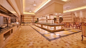 Um amplo hall de hotel com ilha central, área de estar e buffet.