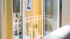 Um edifício amarelo com janela e guarda-corrimão branco.