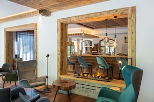 Um interior acolhedor com área de bar em madeira, assentos e lareira.